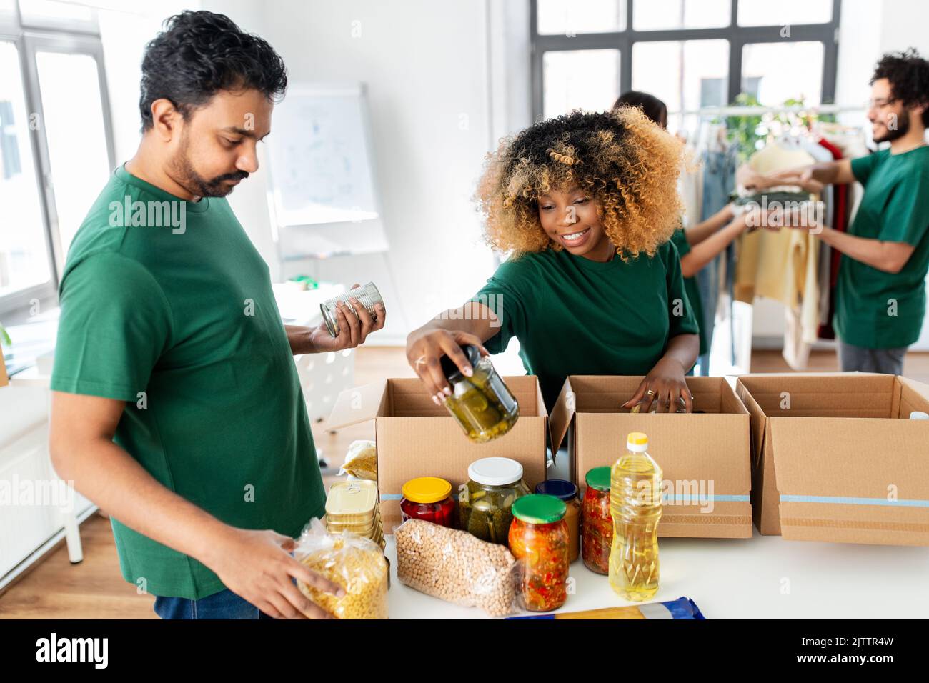 happy volunteers packing food in donation boxes Stock Photo - Alamy