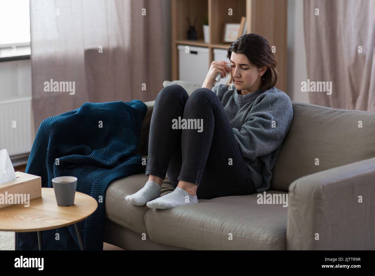 Sad woman crying on sofa hi-res stock photography and images - Alamy