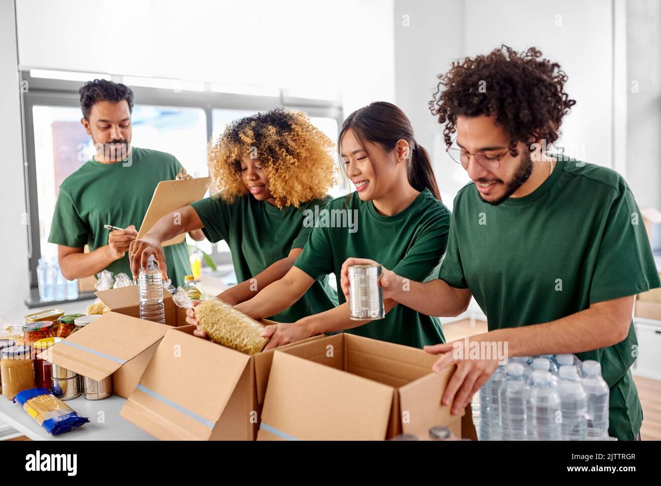 happy volunteers packing food in donation boxes Stock Photo - Alamy
