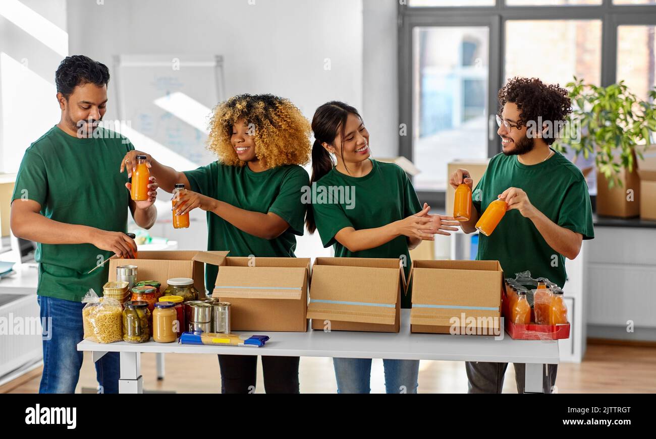 happy volunteers packing food in donation boxes Stock Photo - Alamy
