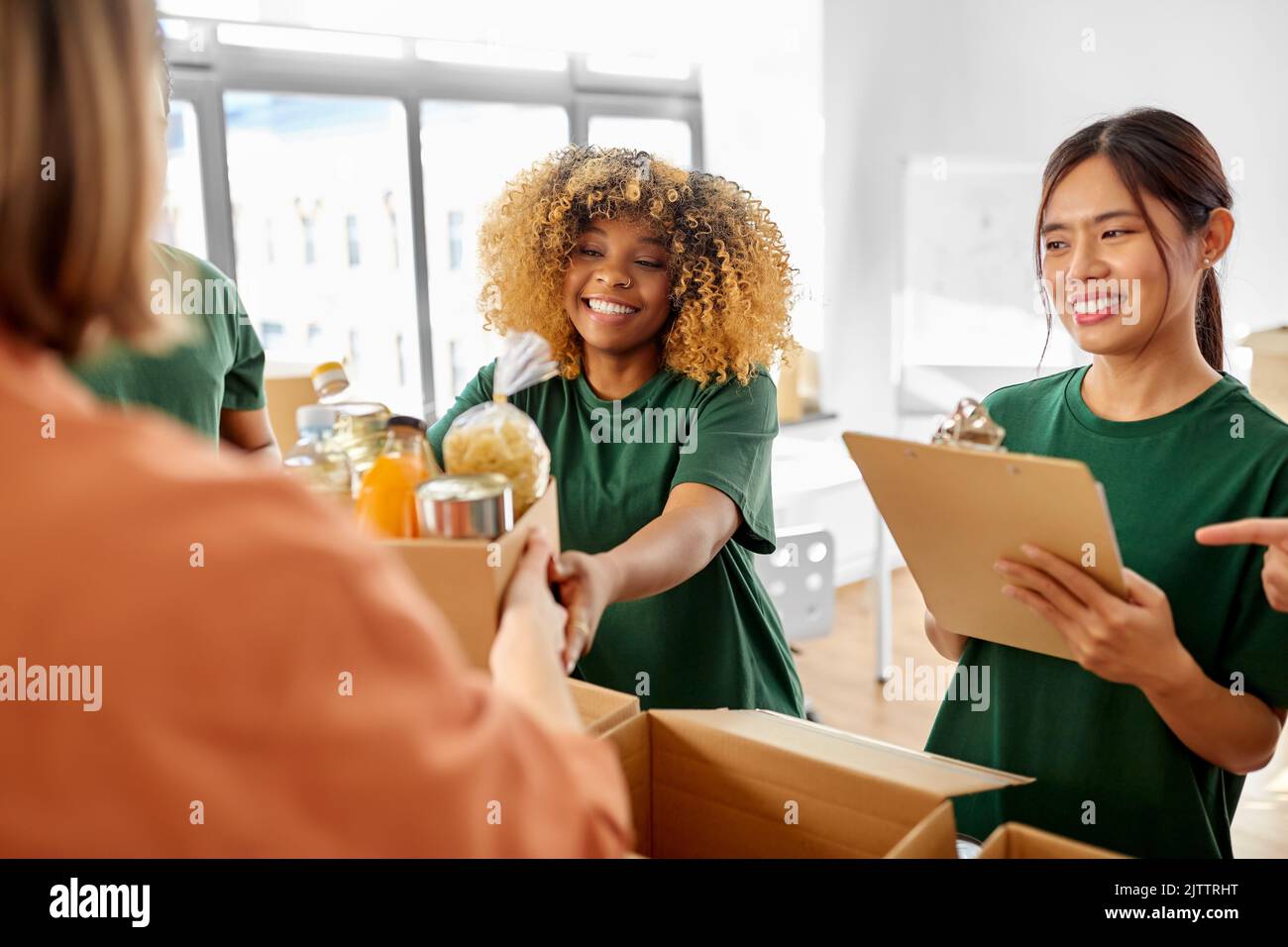 happy volunteers packing food in donation boxes Stock Photo - Alamy