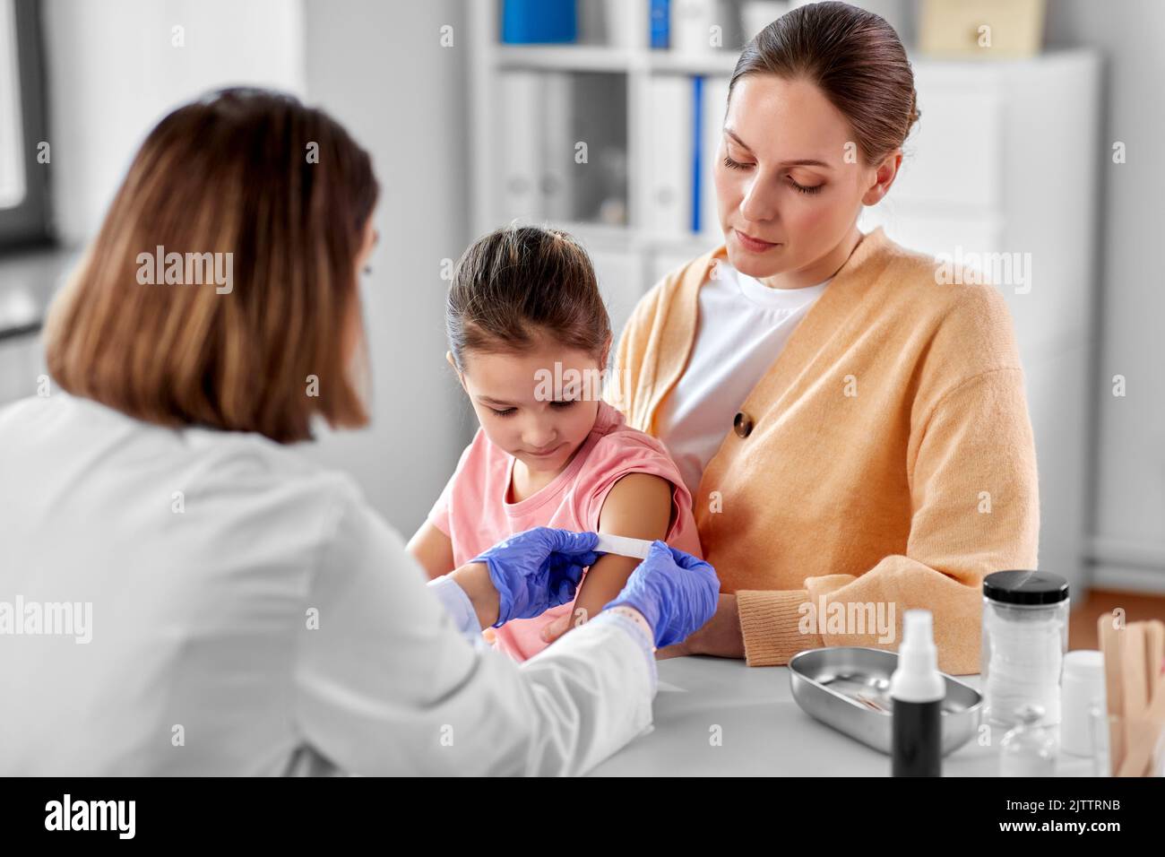 doctor sticking patch to child's arm at clinic Stock Photo - Alamy
