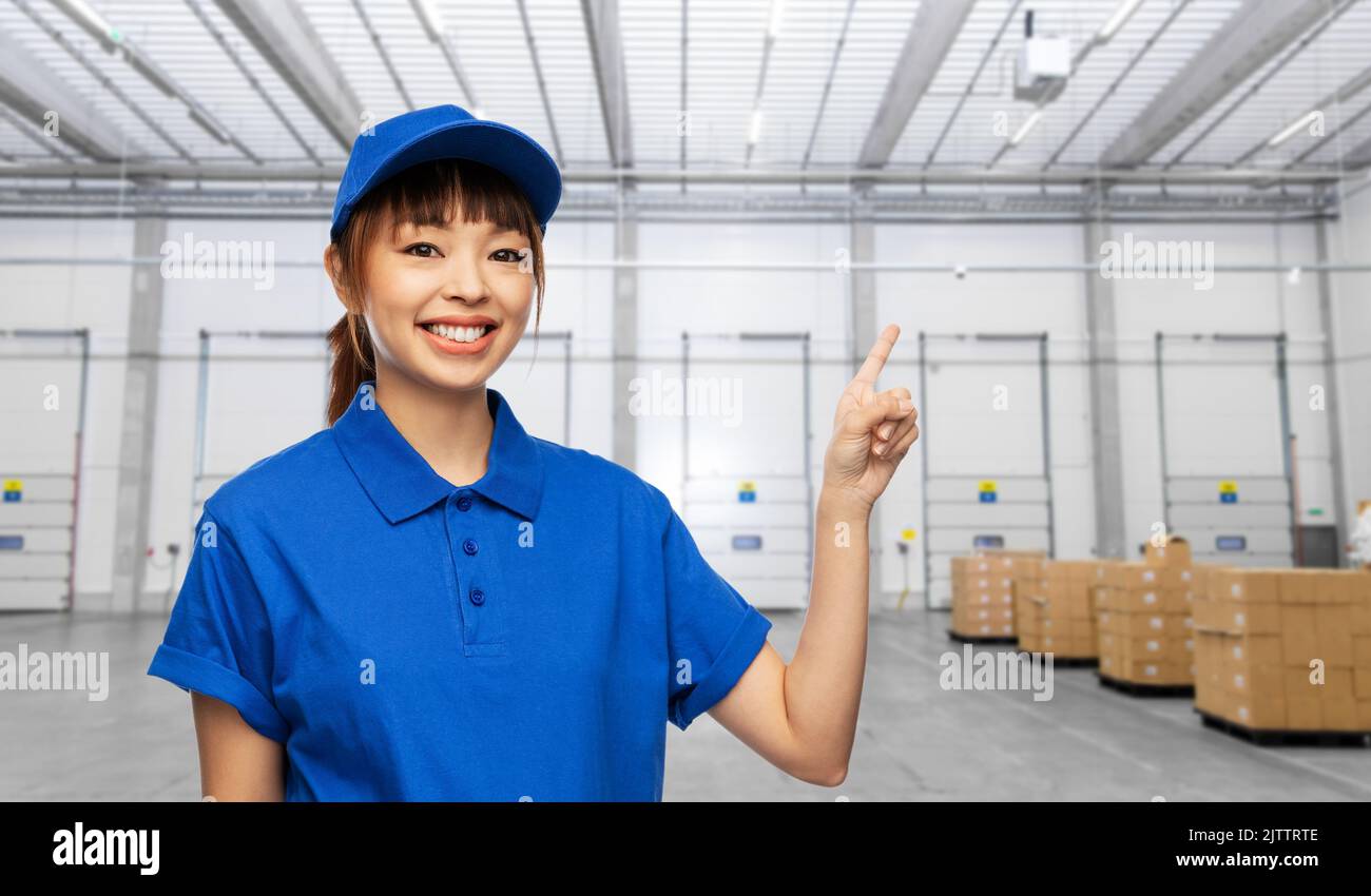 happy smiling delivery woman over warehouse Stock Photo - Alamy