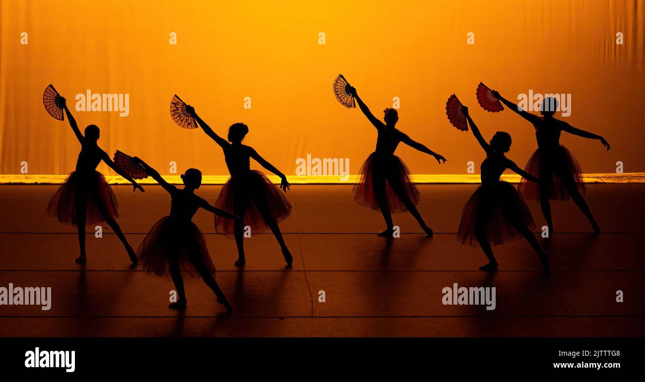 A silhouette of the females dancing with fans Stock Photo - Alamy