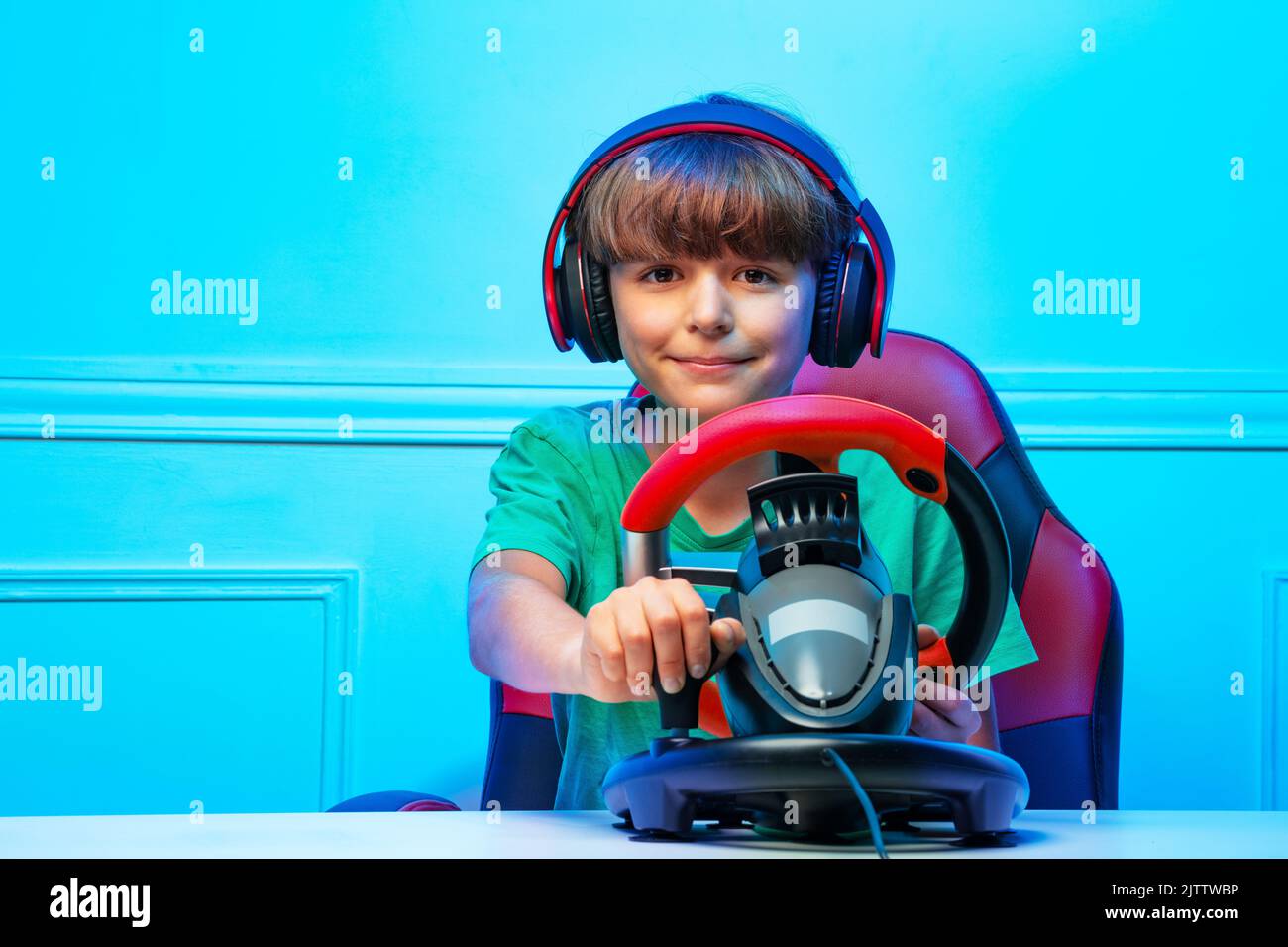 Smiling boy in headphones with steering wheel play race game Stock ...