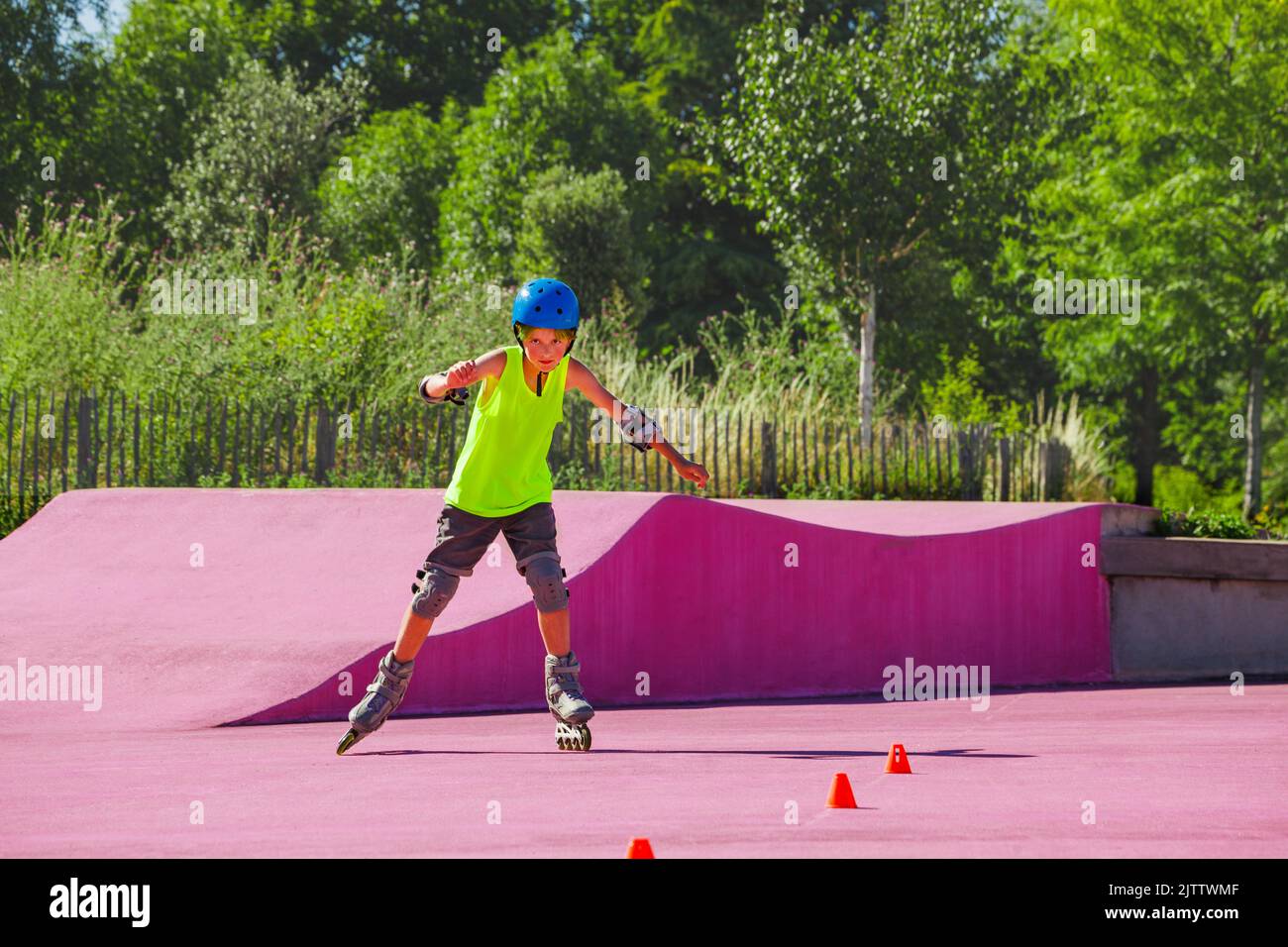 Boy in blue helmet skate fast on rollerblades around cones Stock Photo ...