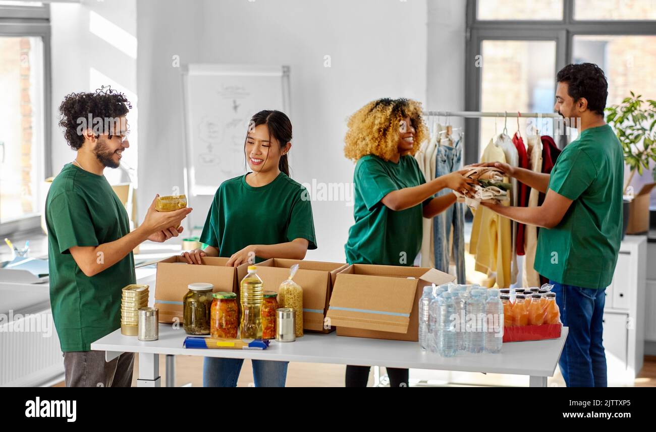 happy volunteers packing food and clothes in boxes Stock Photo - Alamy
