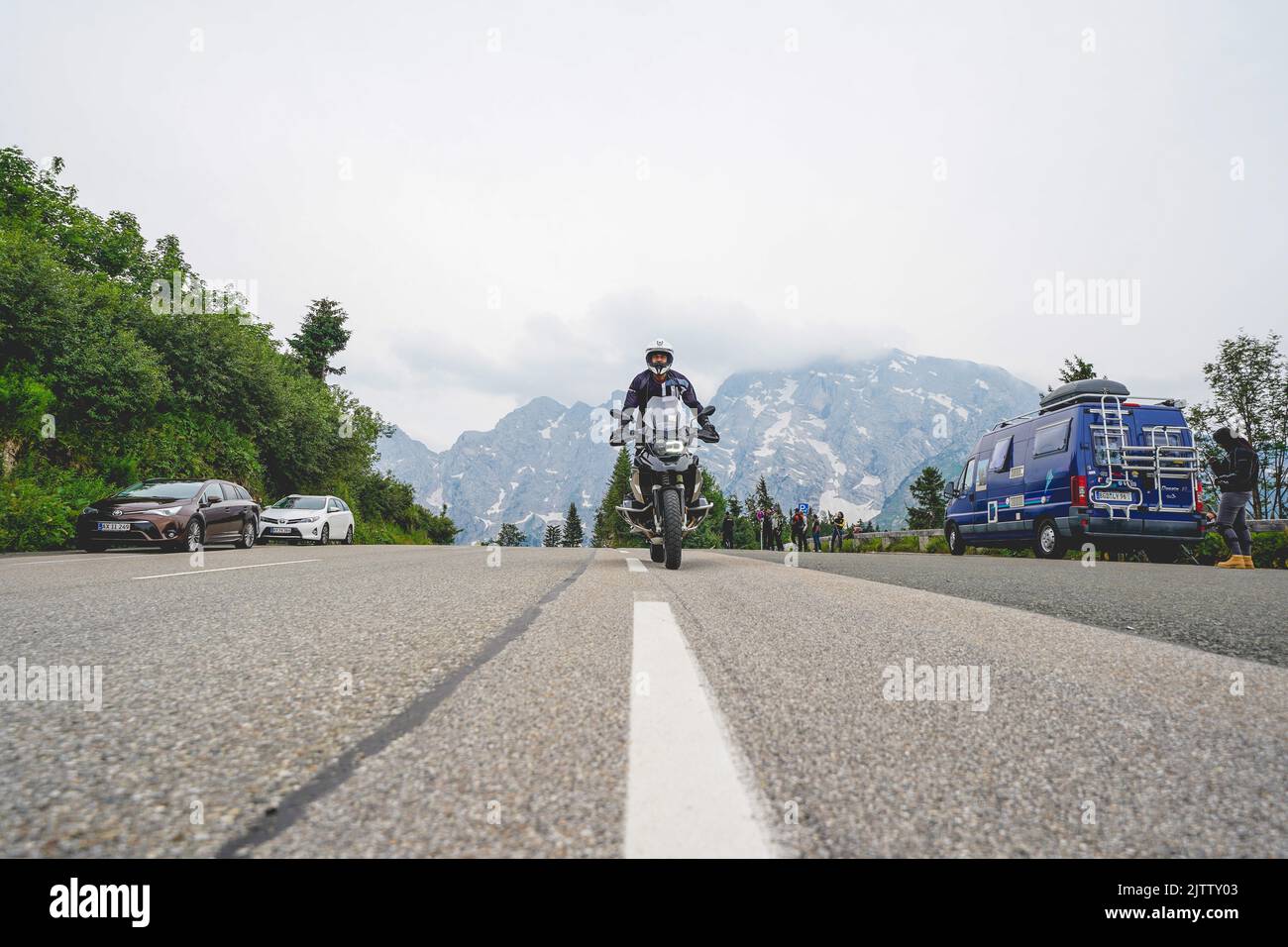 A motorcycle on the middle of the road with a foggy scenery of a high ...