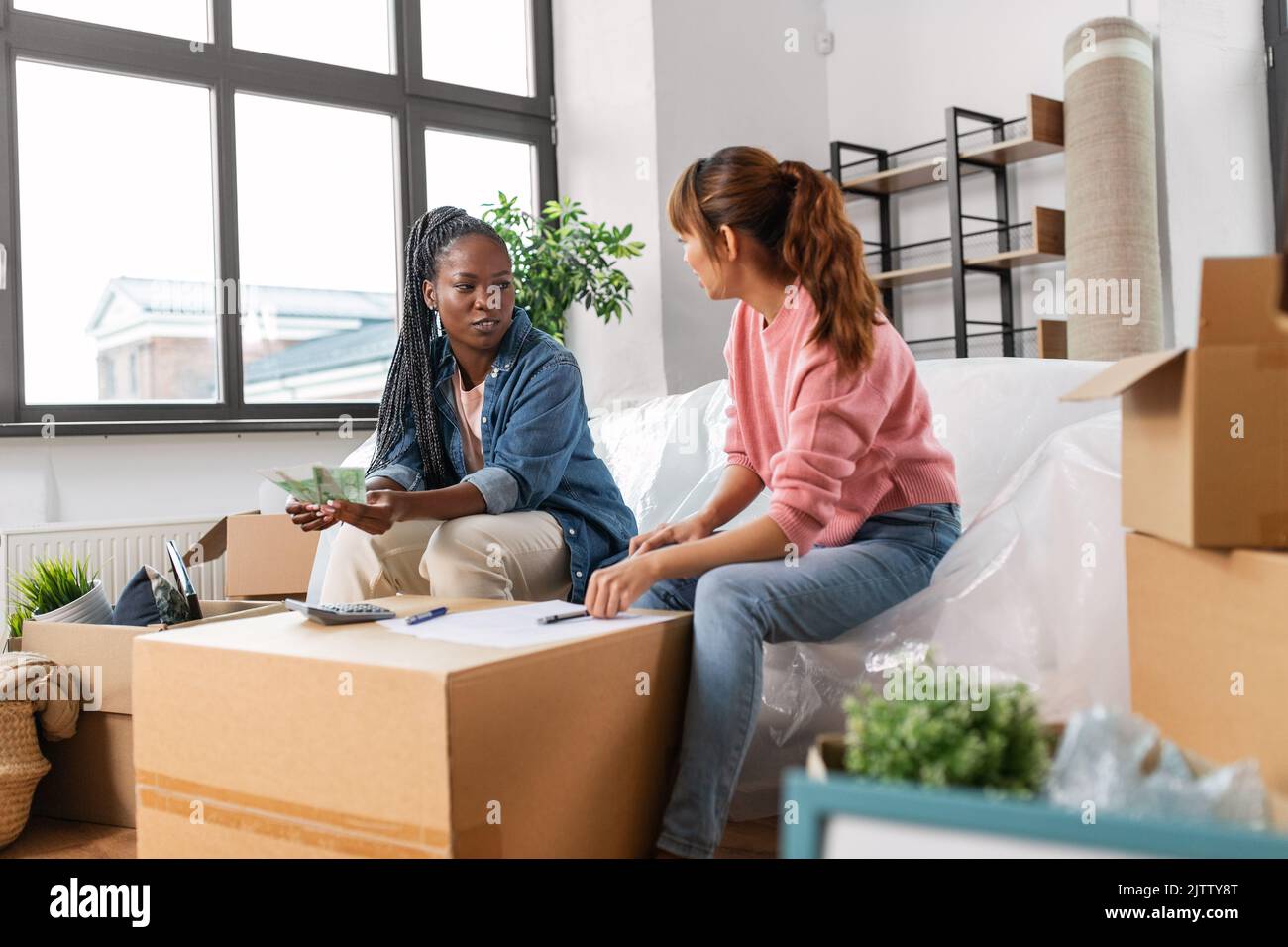 women moving to new home and counting money Stock Photo - Alamy