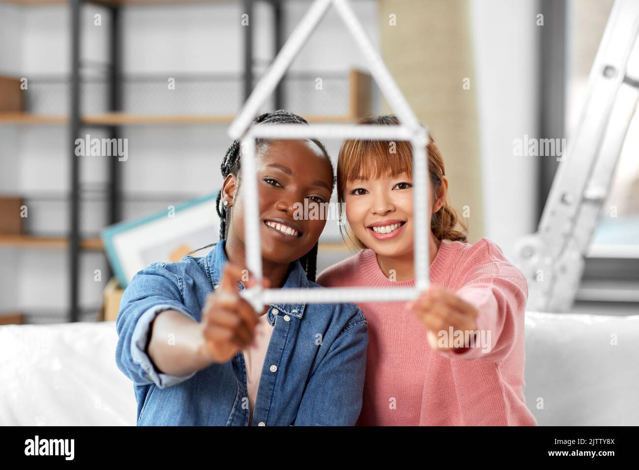 happy smiling women with ruler in shape of house Stock Photo - Alamy