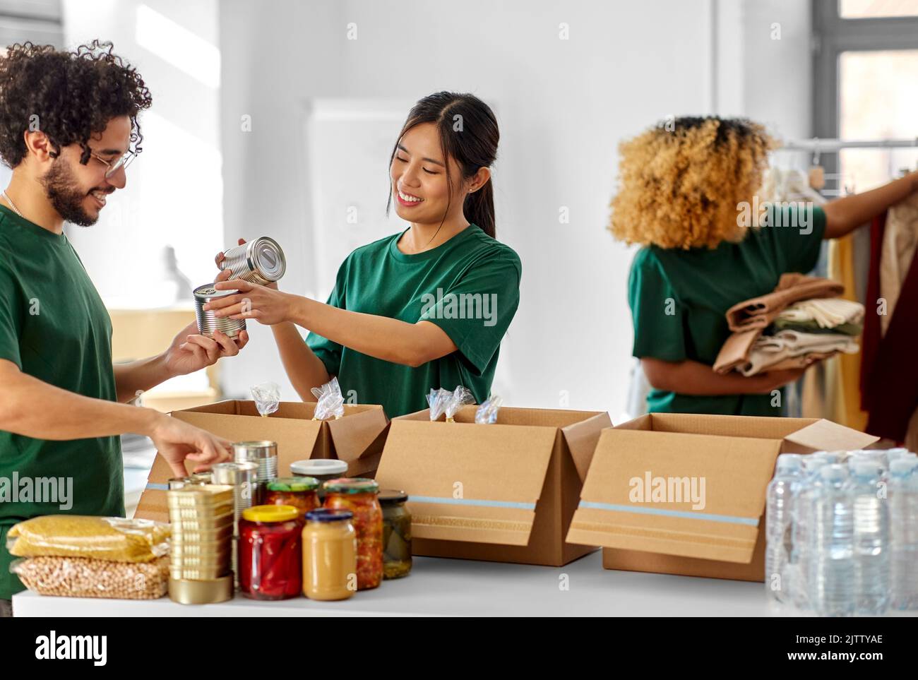 happy volunteers packing food and clothes in boxes Stock Photo - Alamy