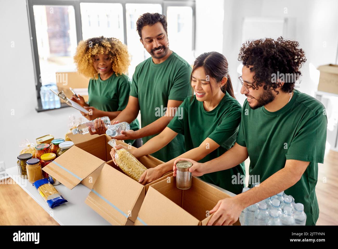 happy volunteers packing food in donation boxes Stock Photo - Alamy