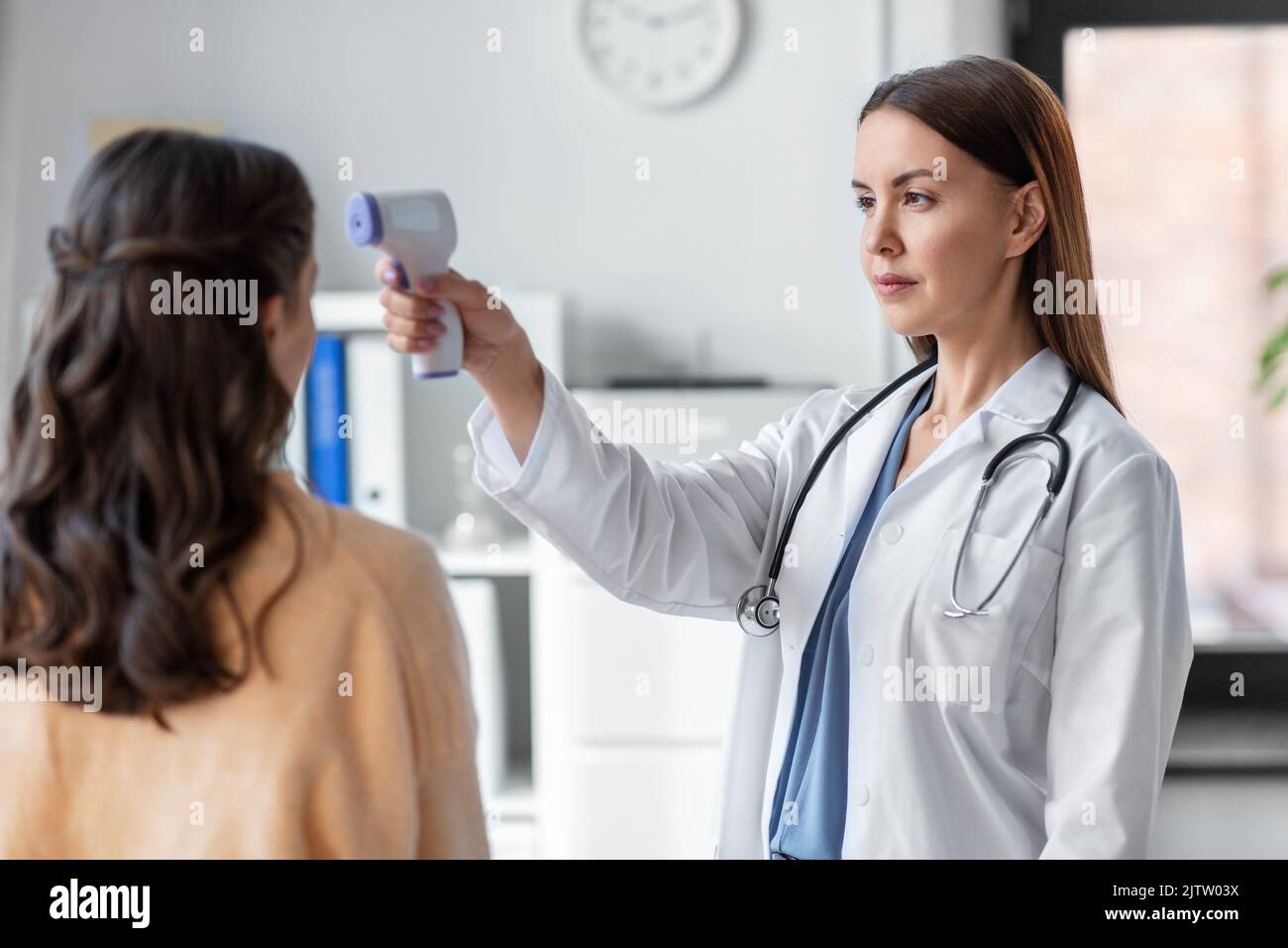 doctor with thermometer and woman at hospital Stock Photo - Alamy