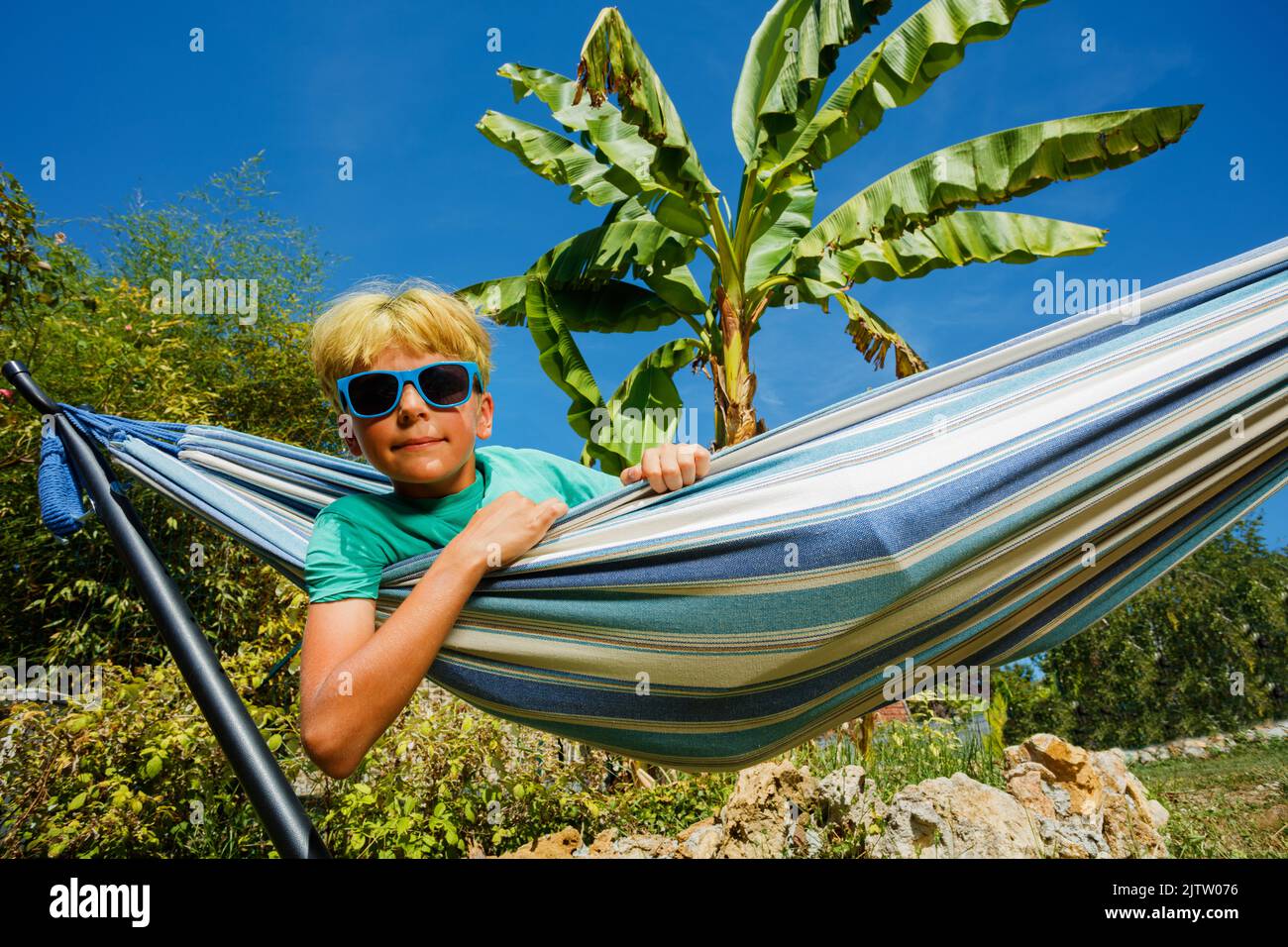 Boy rest in hammock at the garden over palm tree Stock Photo - Alamy