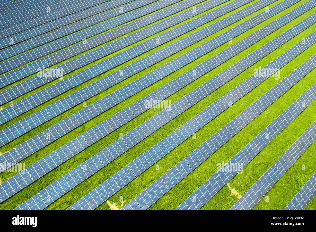 Long rows of sun panels built on green field. Innovative photovoltaic ...