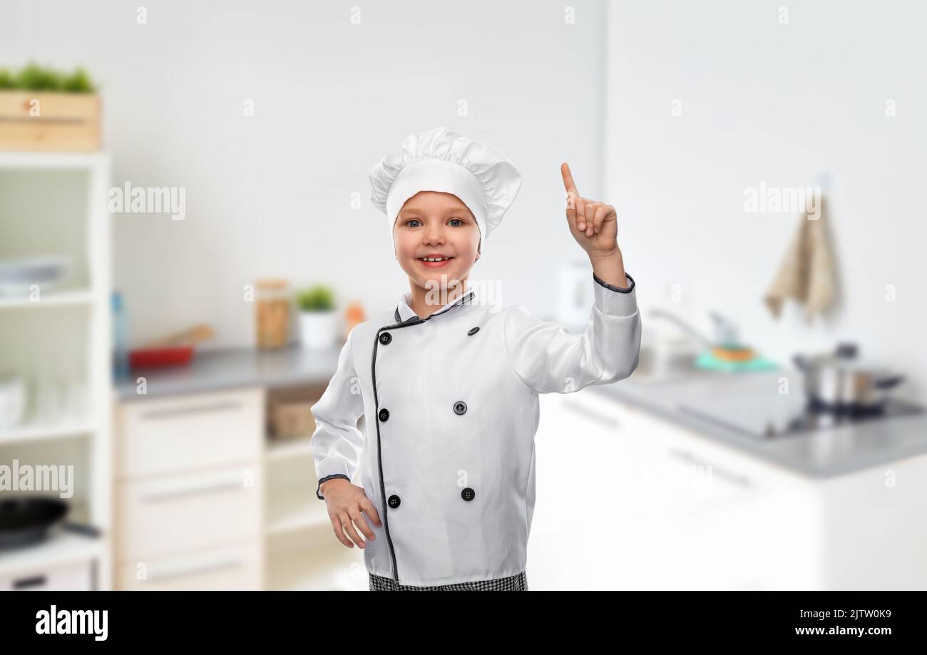 girl in chef's toque pointing finger up in kitchen Stock Photo - Alamy