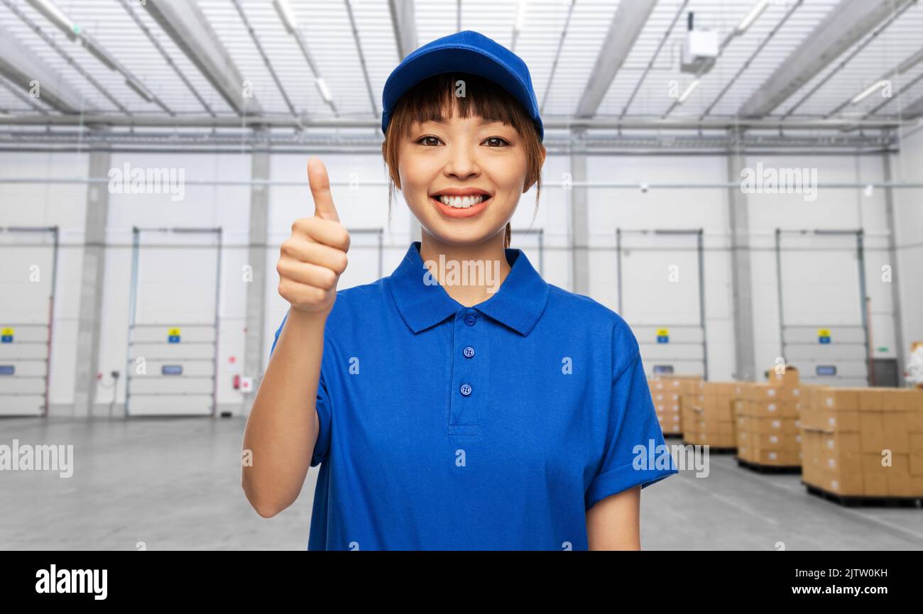 delivery woman showing thumbs up at warehouse Stock Photo - Alamy