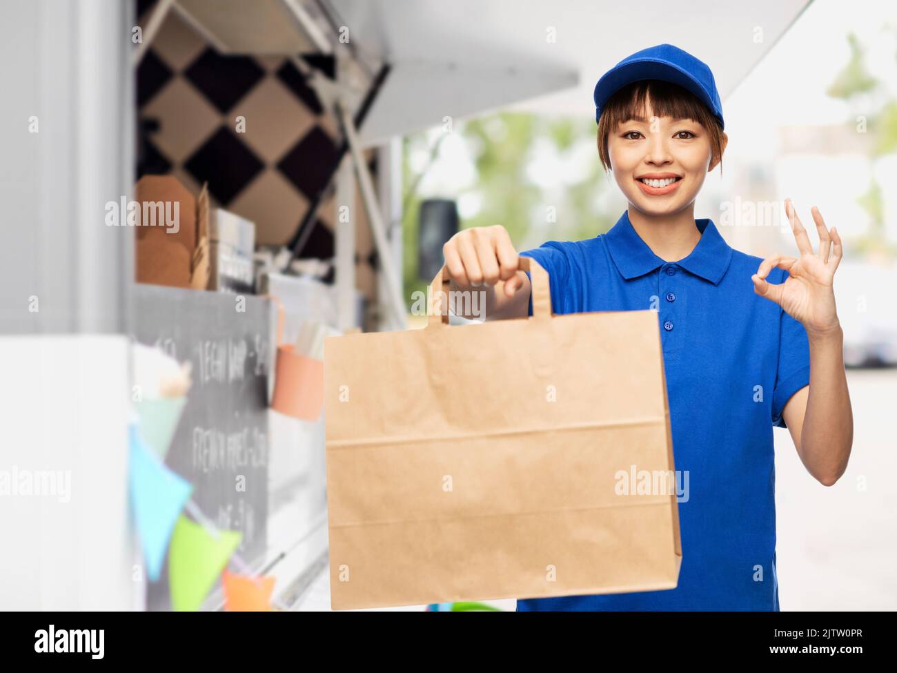 delivery woman with paper bag showing ok sign Stock Photo - Alamy