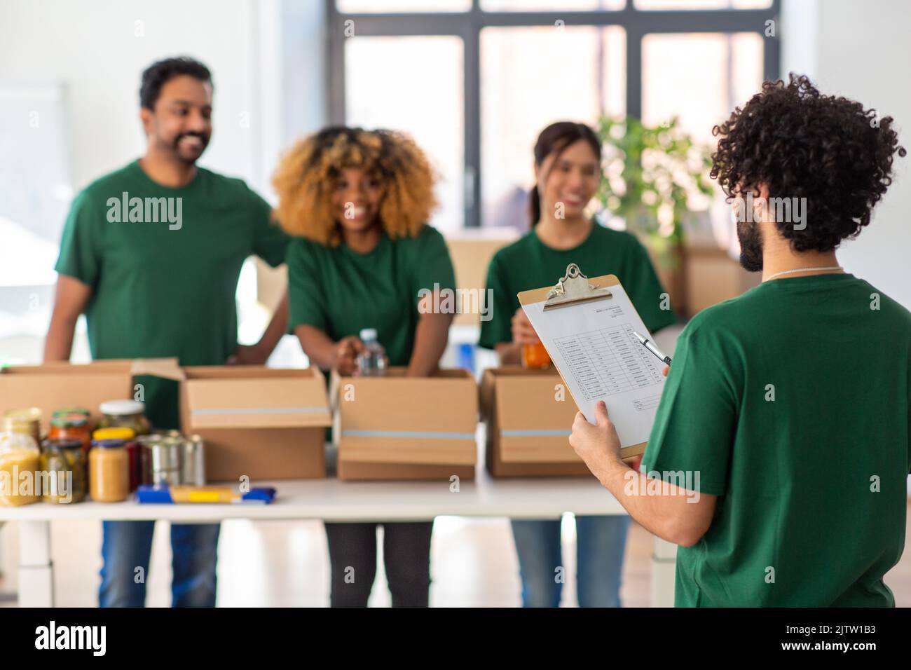 happy volunteers packing food in donation boxes Stock Photo - Alamy