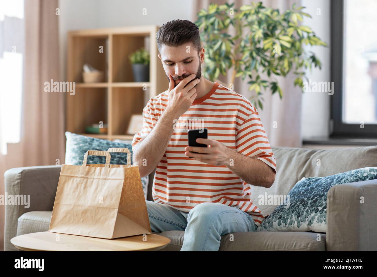 man with phone checking food order at home Stock Photo - Alamy