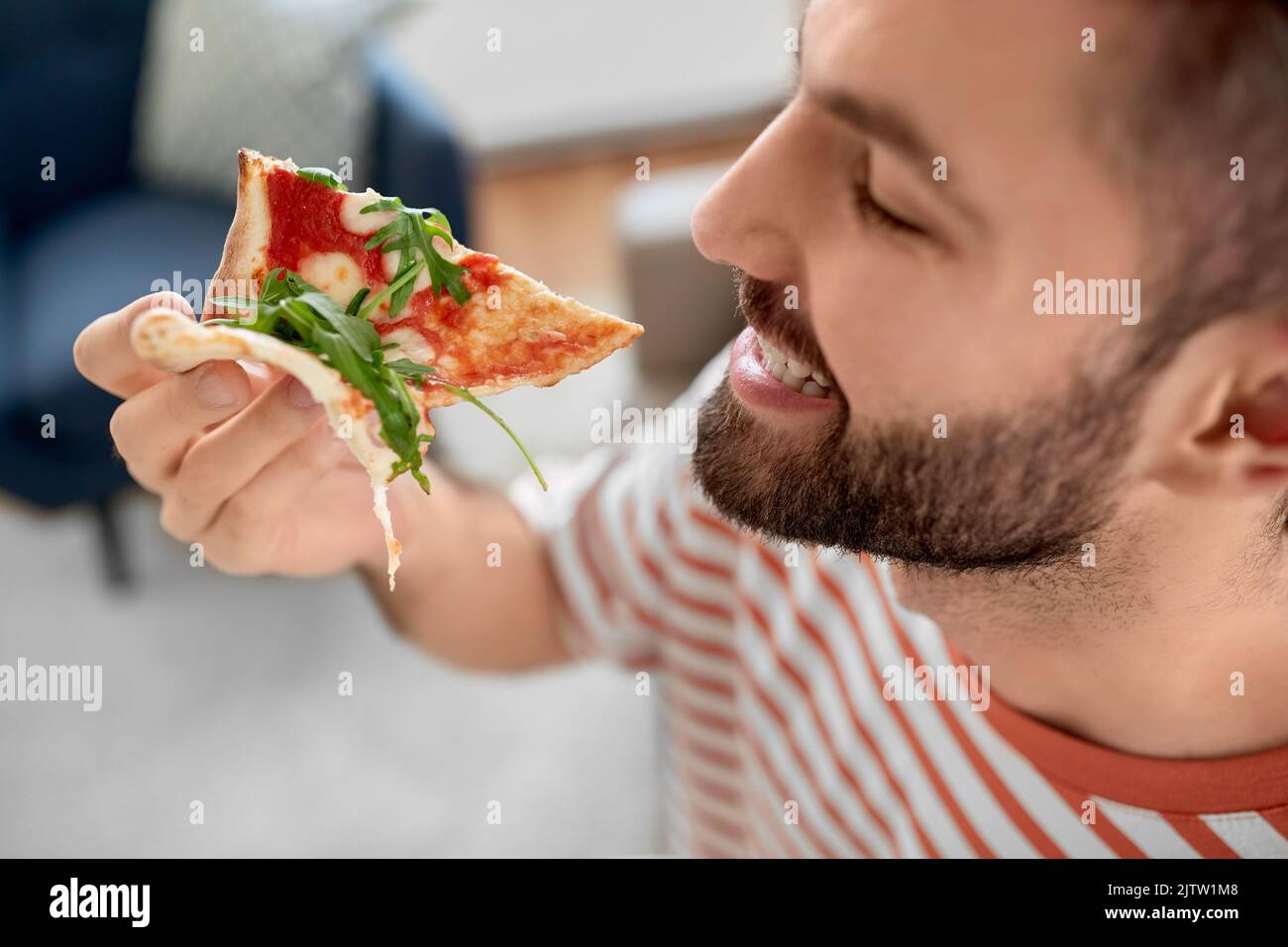 happy man eating takeaway pizza at home Stock Photo - Alamy