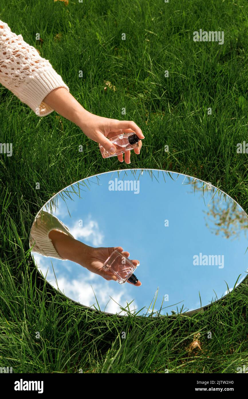 hand with perfume and sky reflection in mirror Stock Photo - Alamy