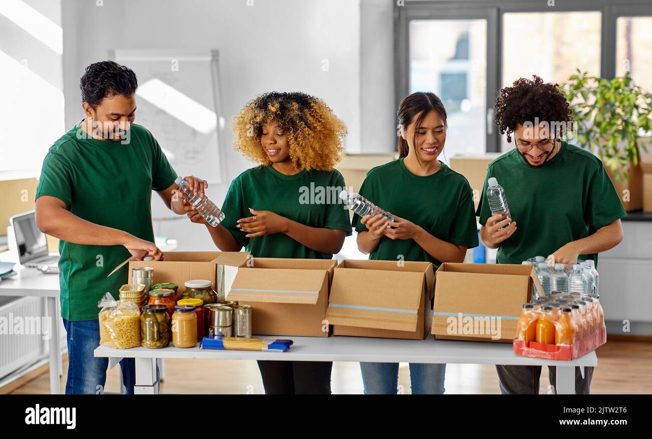 happy volunteers packing food in donation boxes Stock Photo - Alamy