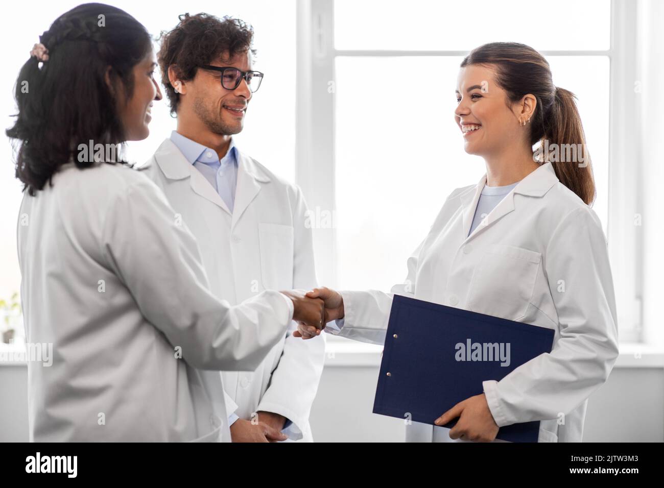 scientists shaking hands in laboratory Stock Photo - Alamy