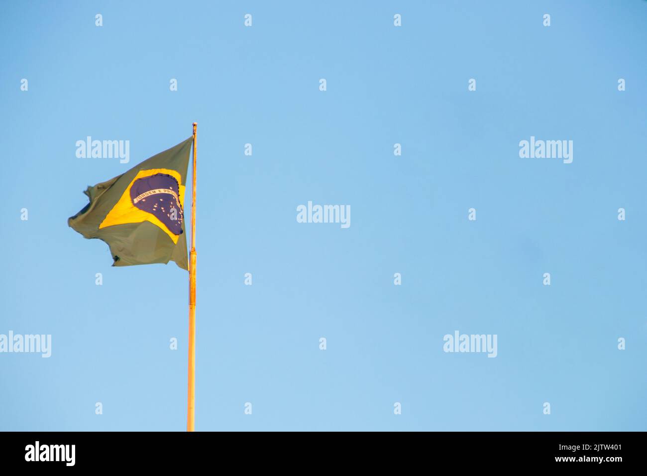 Flag of Brazil outdoors with a beautiful blue sky in the background in ...