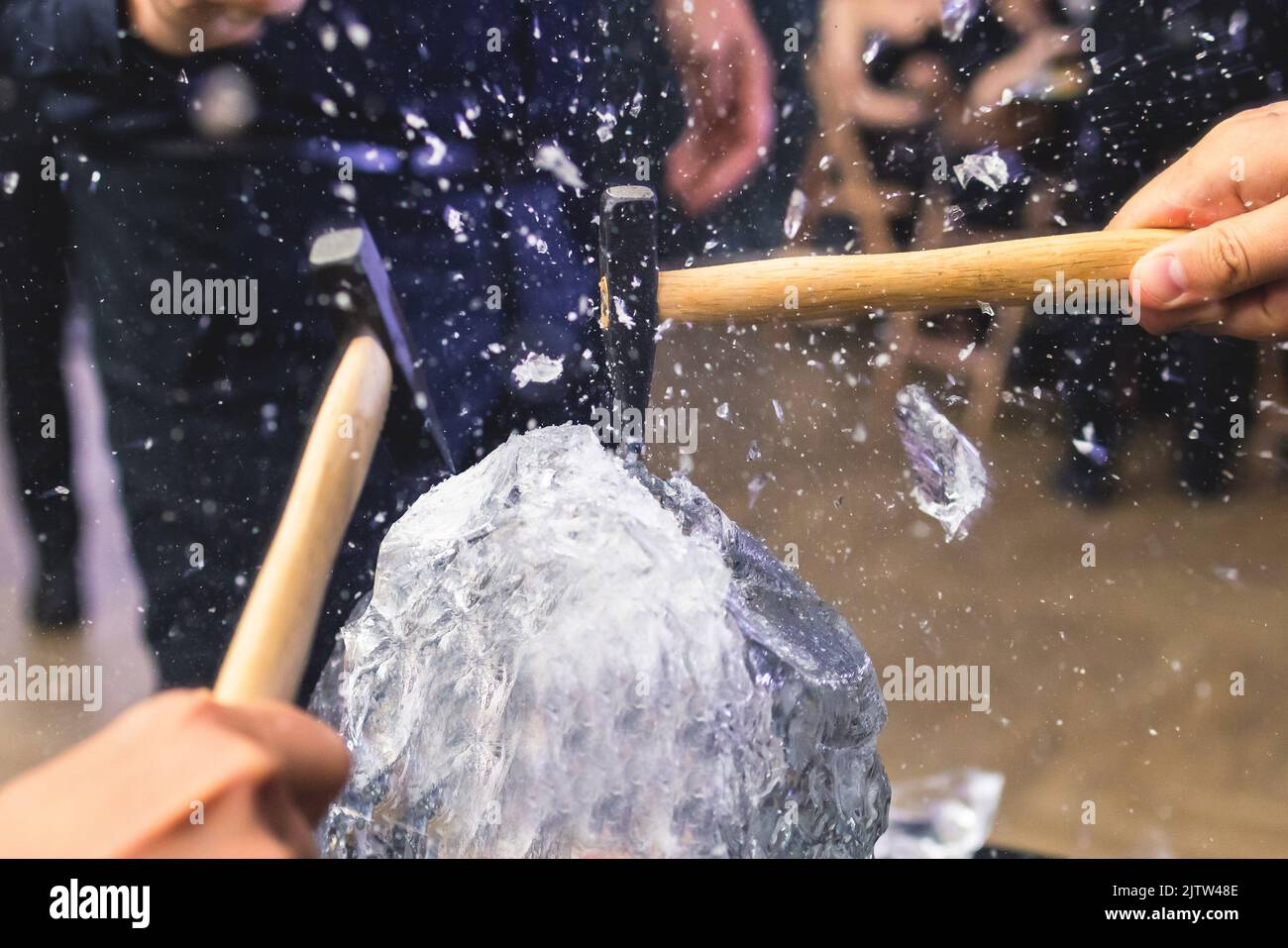 Process of breaking the ice with hammer and ice pick, group of people ...