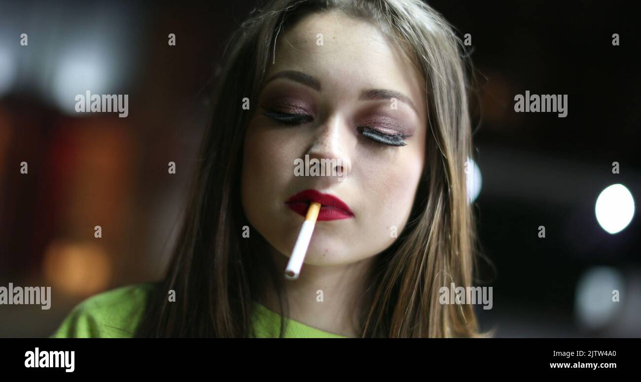 Pretty girl lighting a cigarette at night in nightlife Stock Photo - Alamy