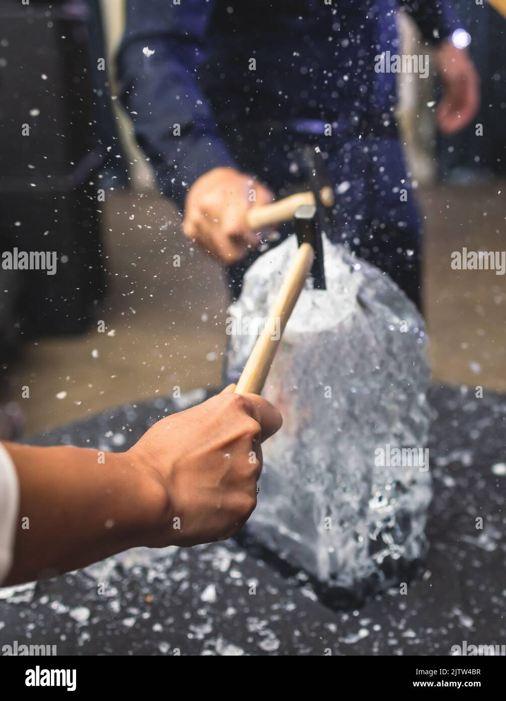 Process of breaking the ice with hammer and ice pick, group of people ...