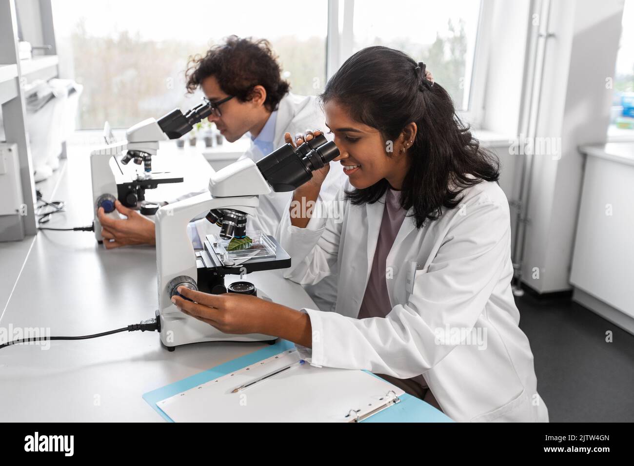scientists with microscopes working in laboratory Stock Photo - Alamy