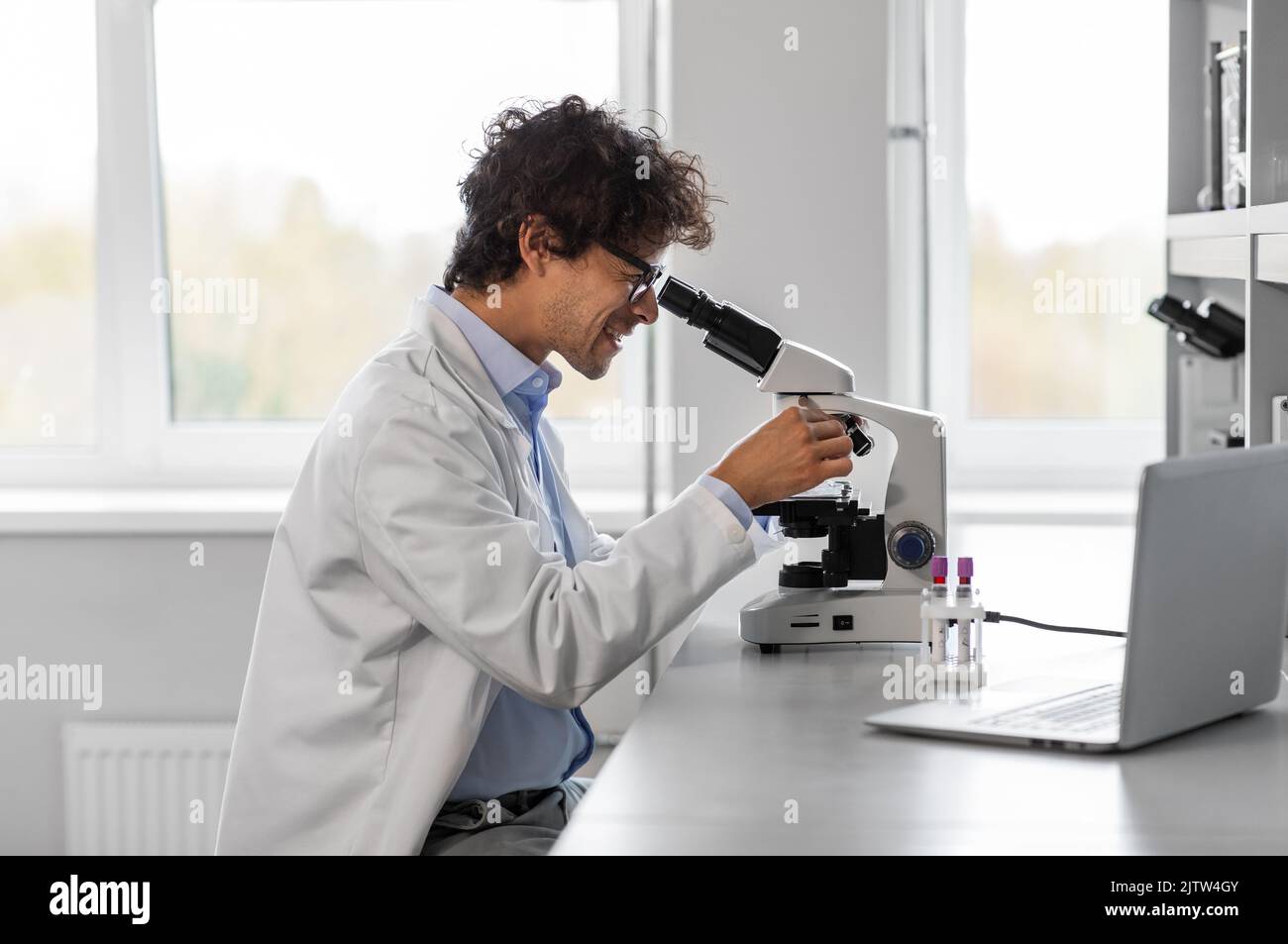 scientist with microscope working in laboratory Stock Photo - Alamy