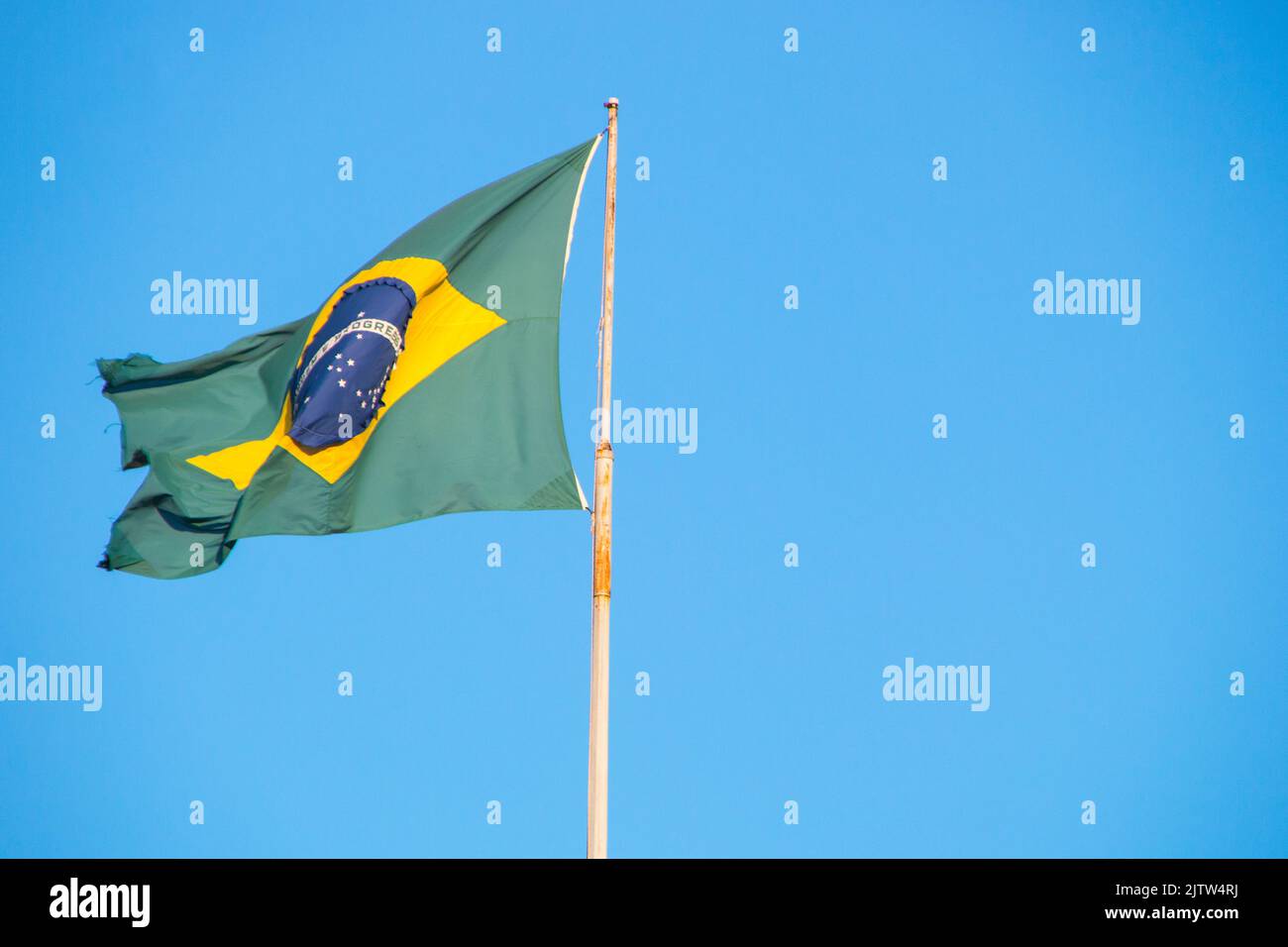 Flag of Brazil outdoors with a beautiful blue sky in the background in ...