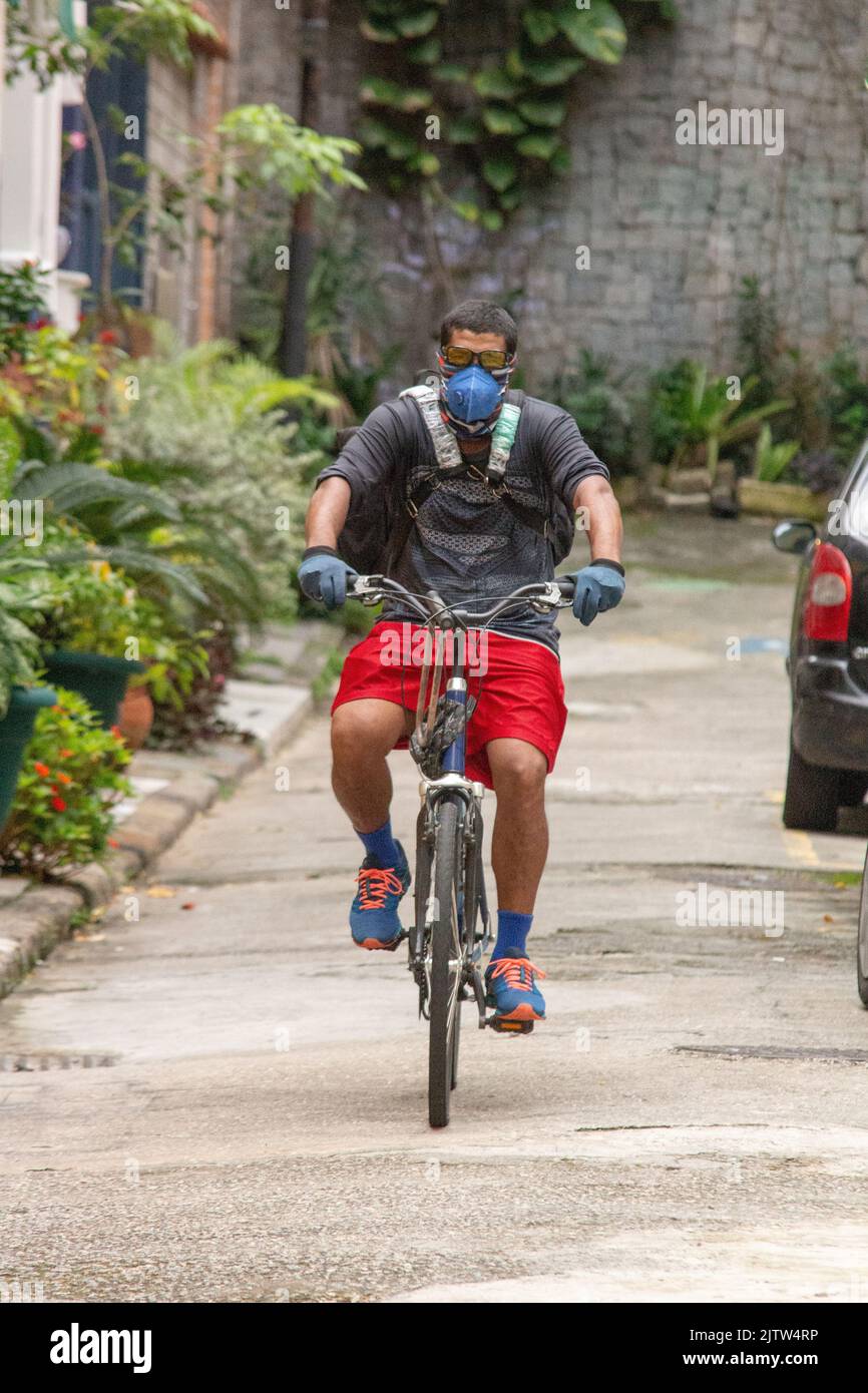 black man delivering food by bicycle on a street in Rio de Janeiro ...