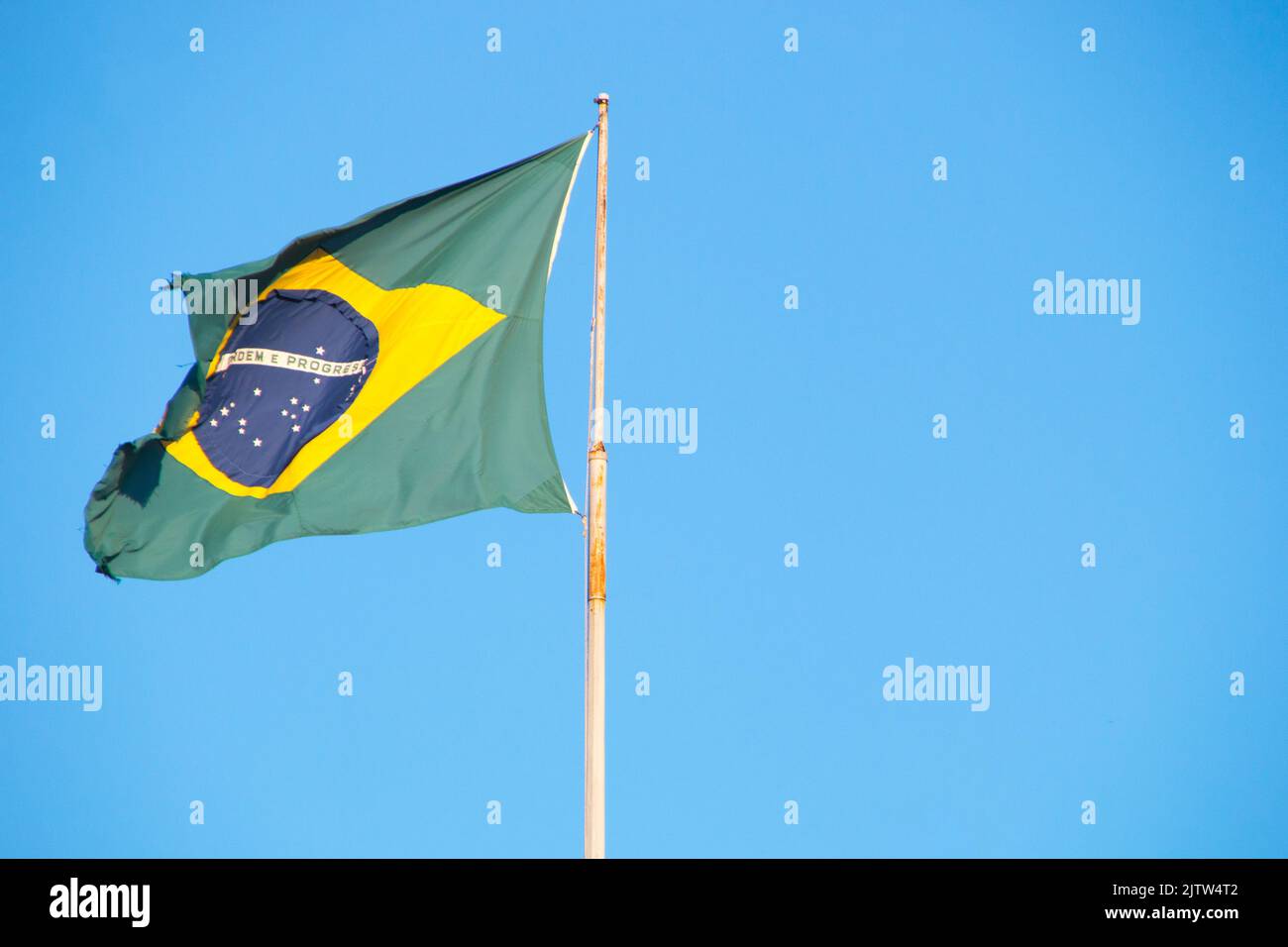 Flag of Brazil outdoors with a beautiful blue sky in the background in ...