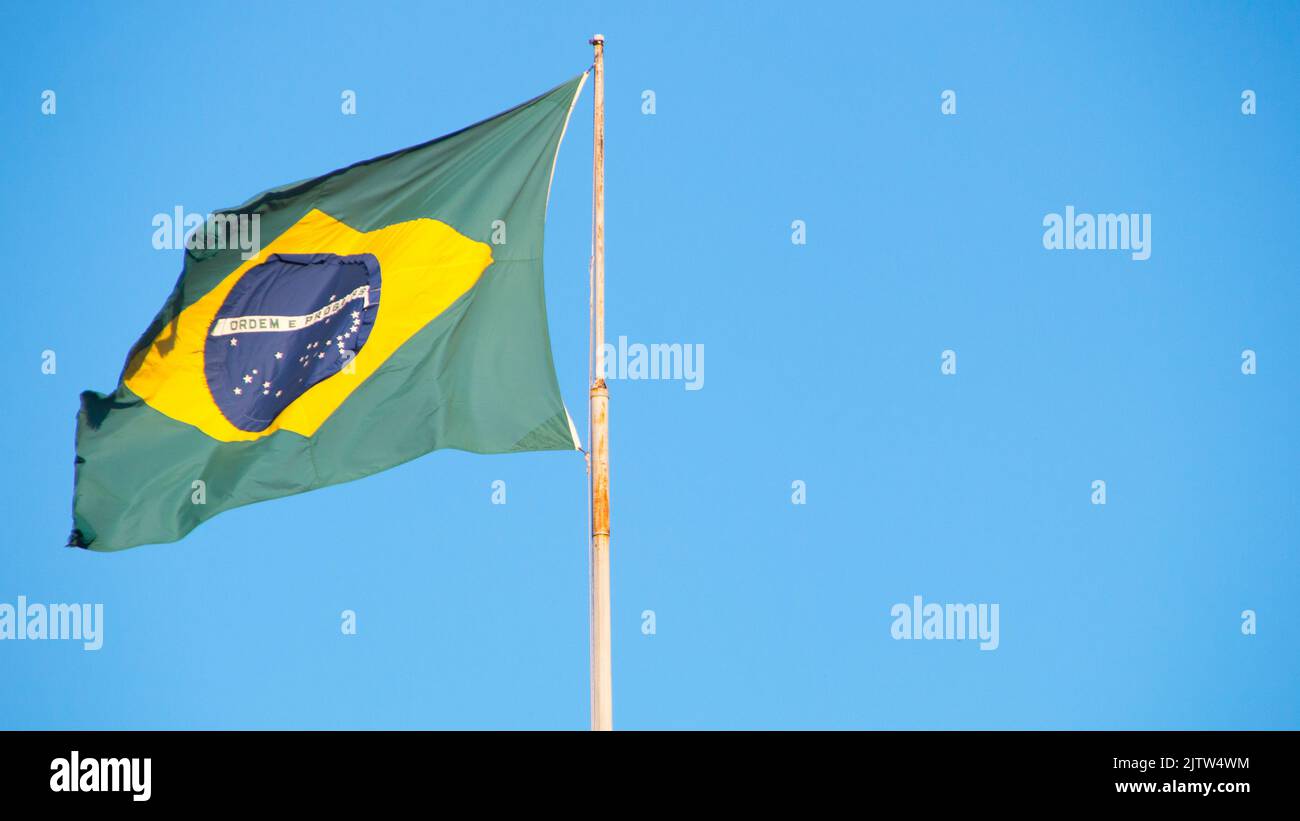 Flag of Brazil outdoors with a beautiful blue sky in the background in ...