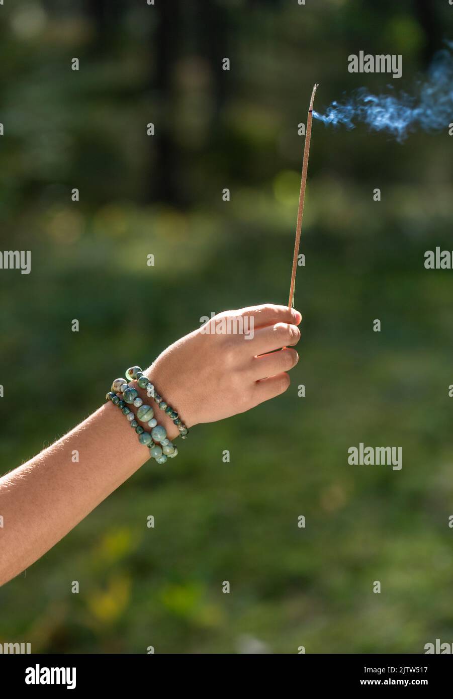hand with smoking incense stick in forest Stock Photo - Alamy