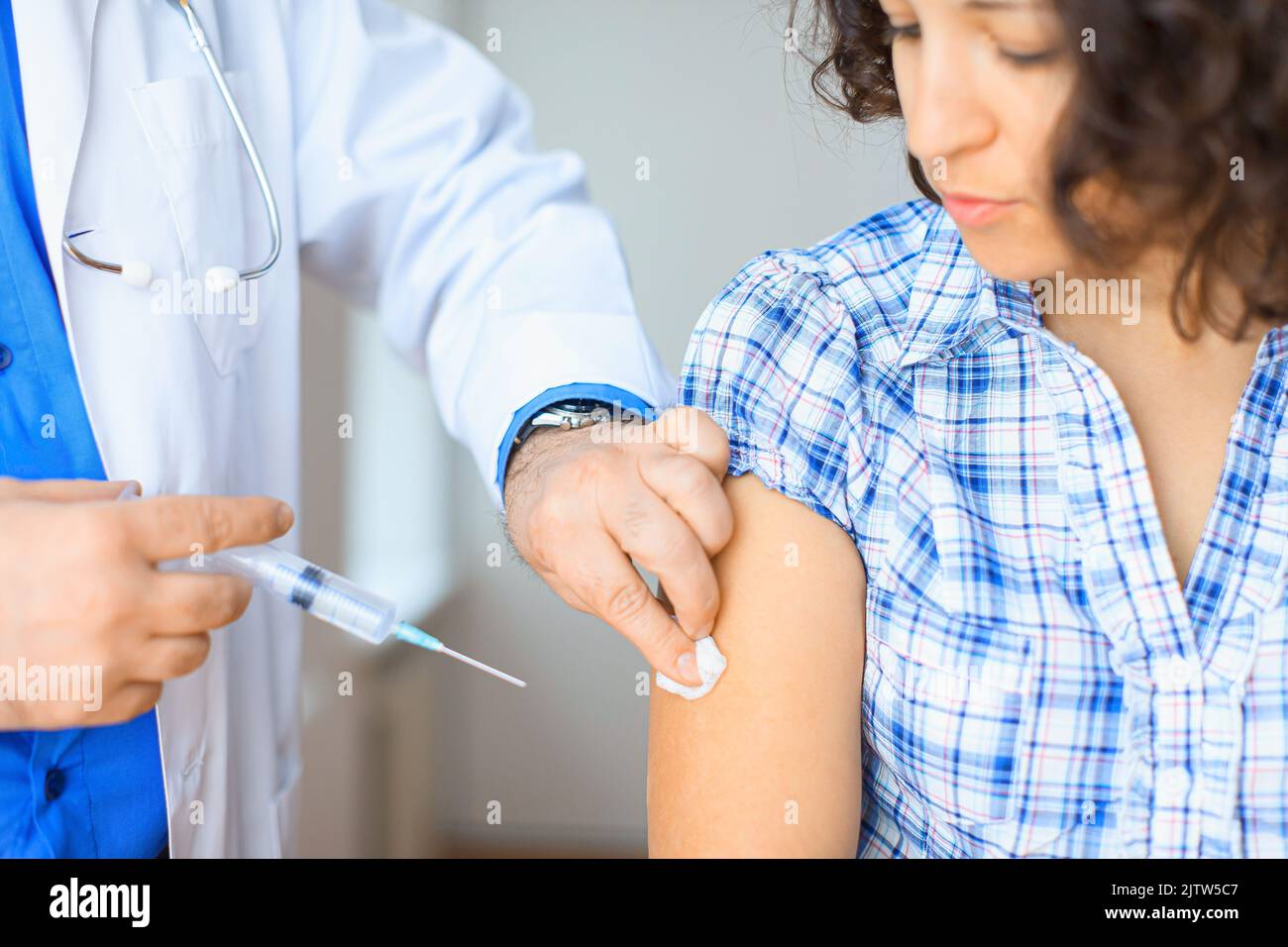 Doctor giving young female patient vaccine syringe Stock Photo - Alamy
