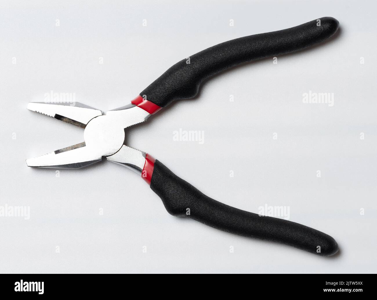 Open steel plier with black rubber grip isolated on studio background ...