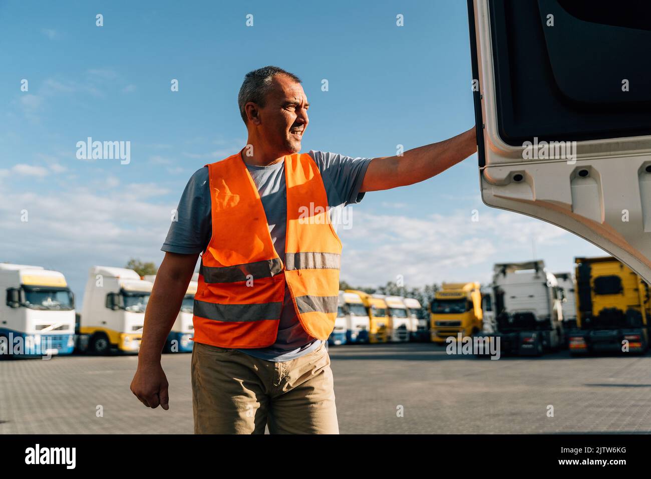 Portrait of caucasian mature man on semi-truck vehicles parking ...