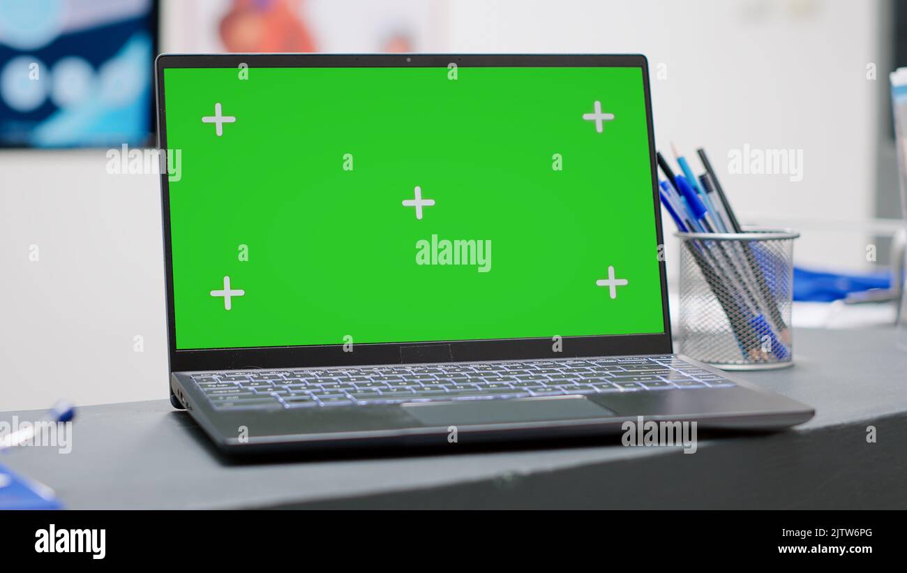 Laptop with greenscreen display on facility reception counter in ...