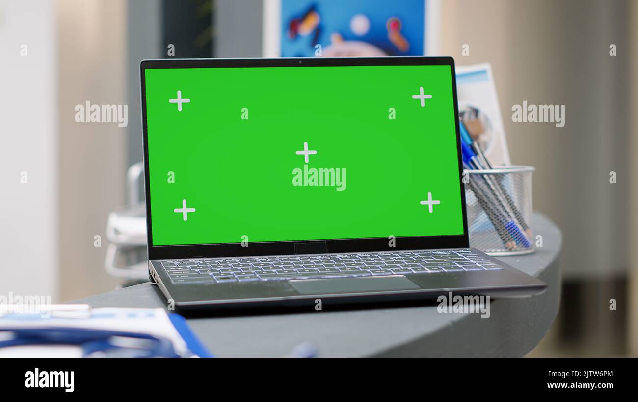 Greenscreen display on laptop at hospital reception desk, private ...
