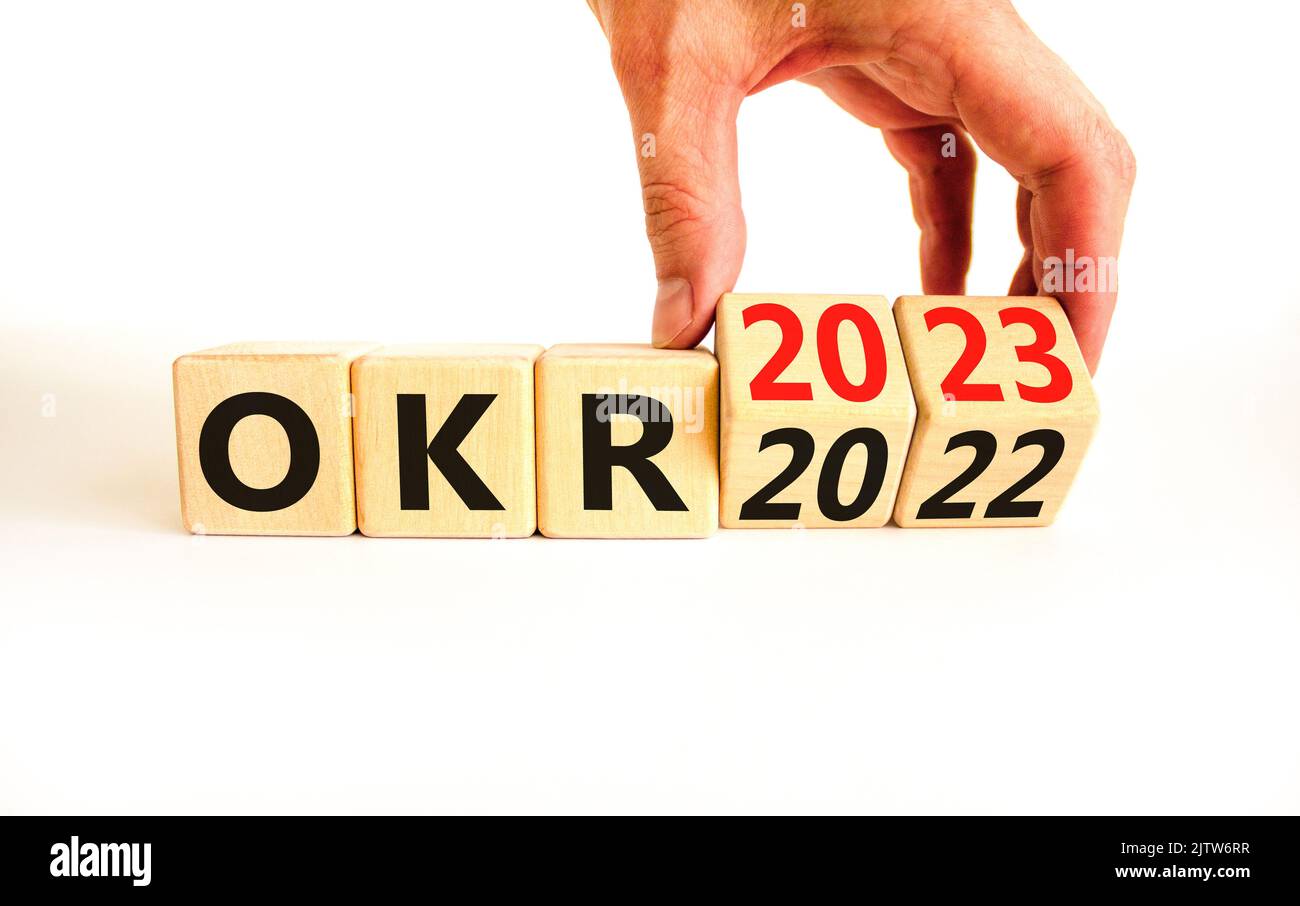 OKR, objectives and key results symbol. Businessman turns cubes with words OKR 2022 and OKR 2023 ...