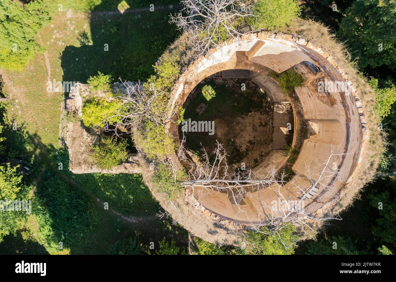 Top down view of abandoned church interior through roofless damaged tower. Old temple ruins in ...