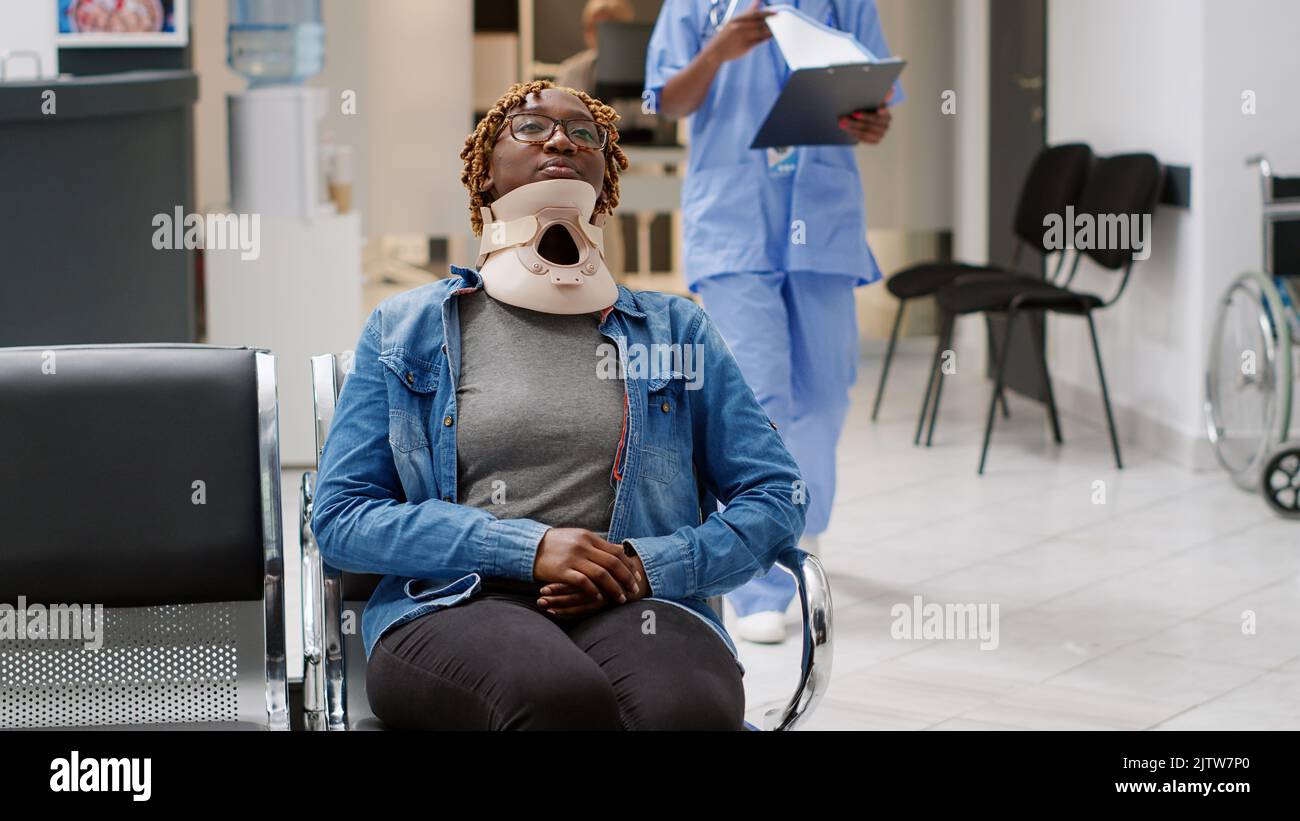 Nurse taking injured patient with medical neck collar to office ...