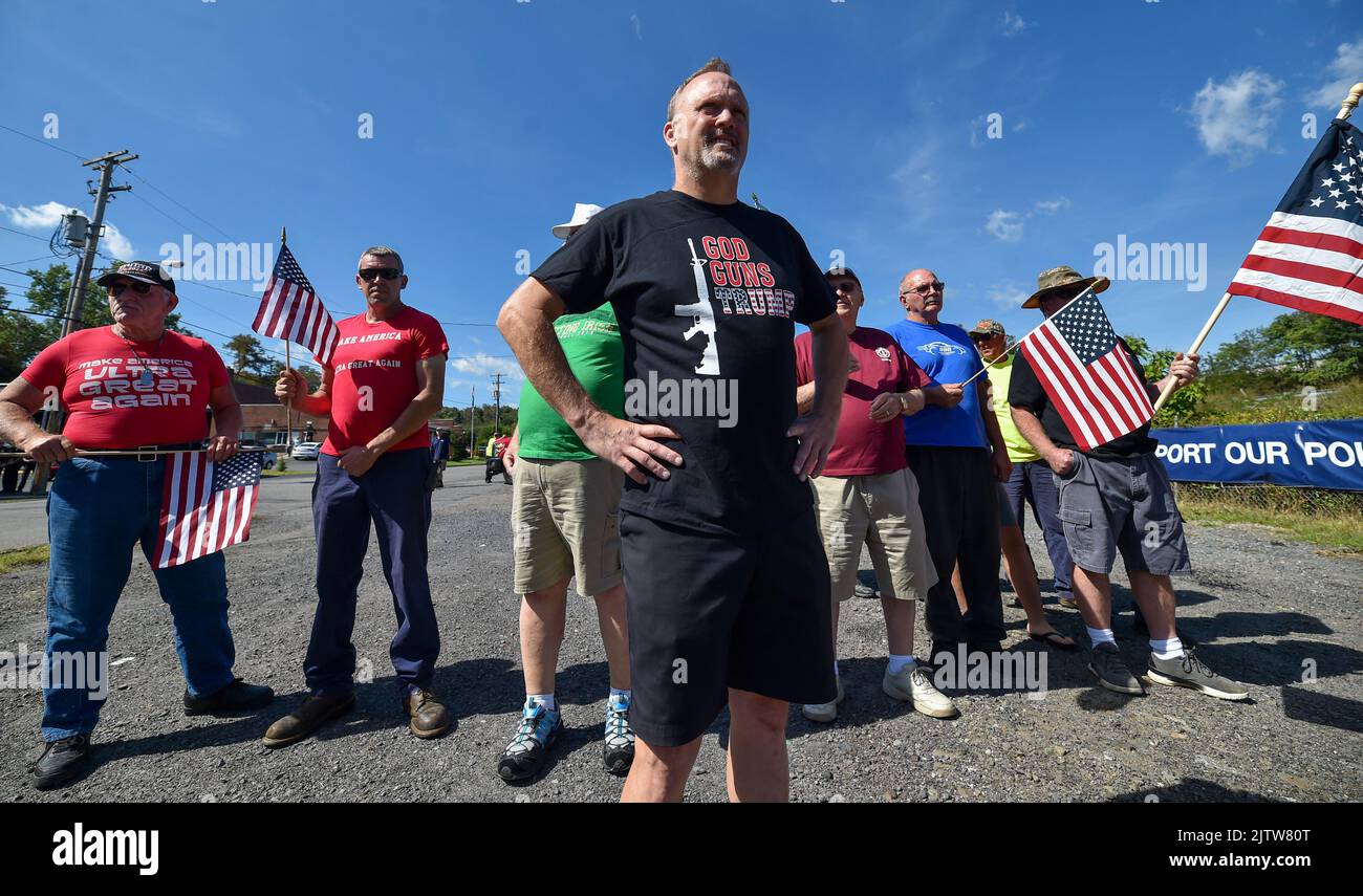 TJ Fitzgerald wears a "God Guns Trump" t-shirt while standing before a ...