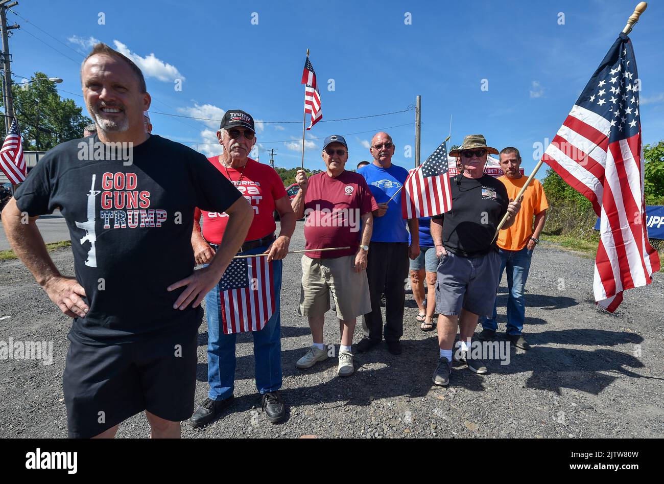 TJ Fitzgerald wears a "God Guns Trump" t-shirt while standing before a ...