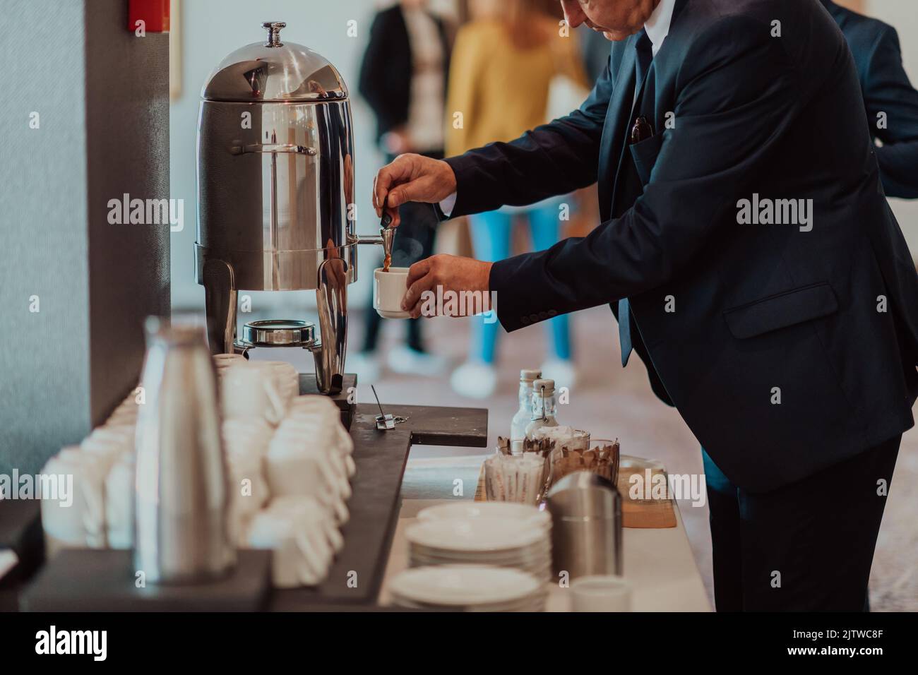Close-up photo of businessmen serving themselves in a modern hotel ...